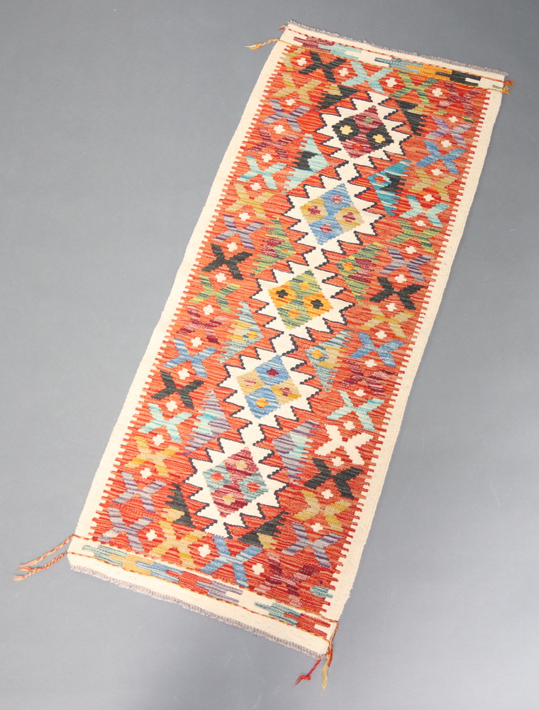 A white, turquoise and orange ground Chobi Kilim | 15th June 2023 | Denhams